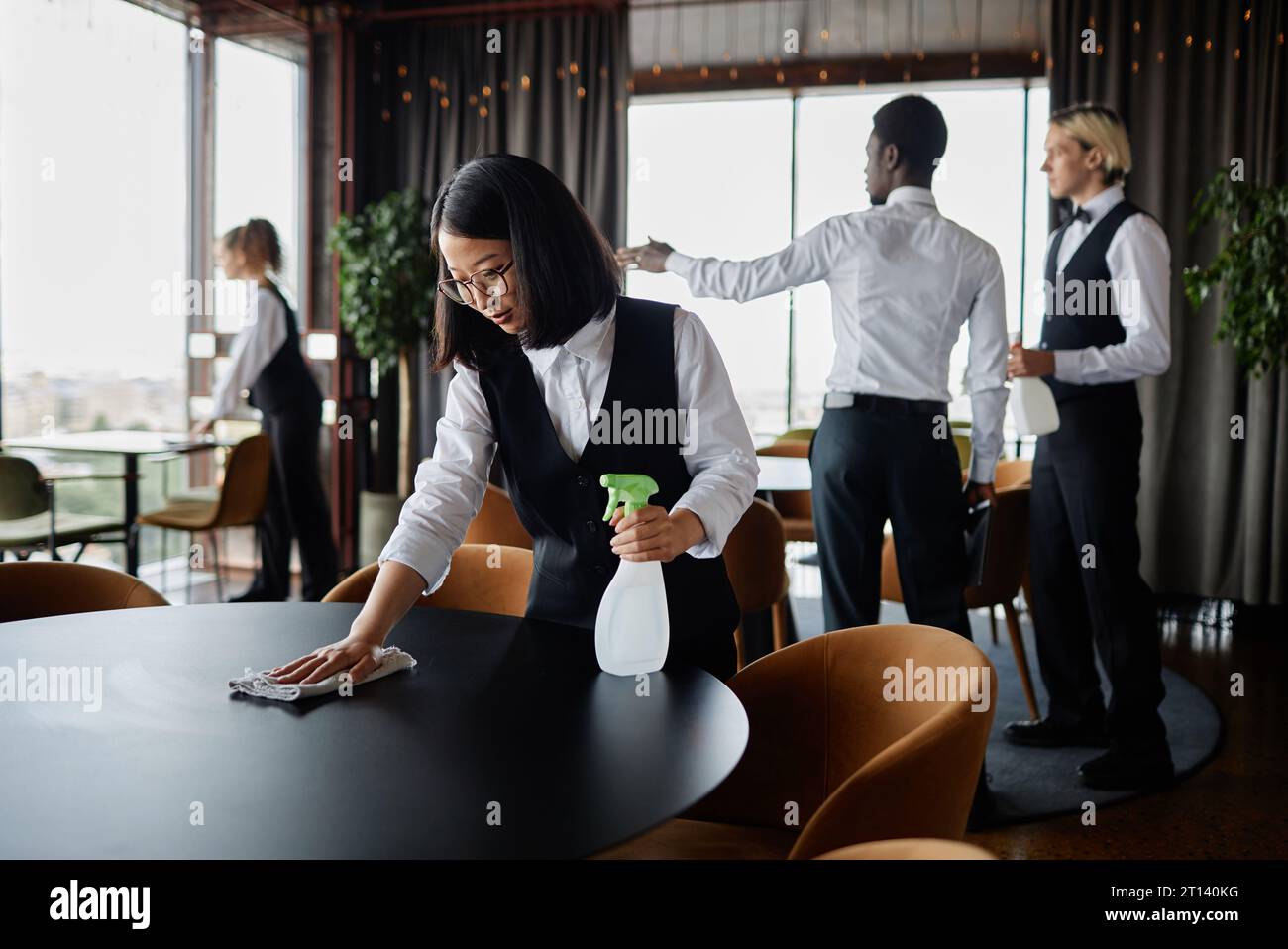 Young waitress wiping table hi-res stock photography and images - Alamy