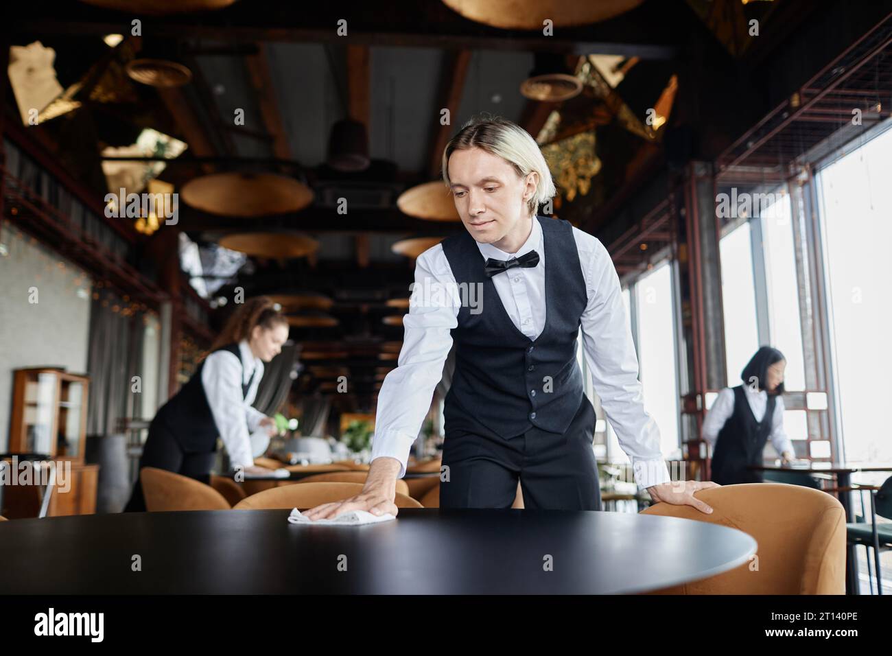Portrait of young man as waiter dressed in classic black and white ...