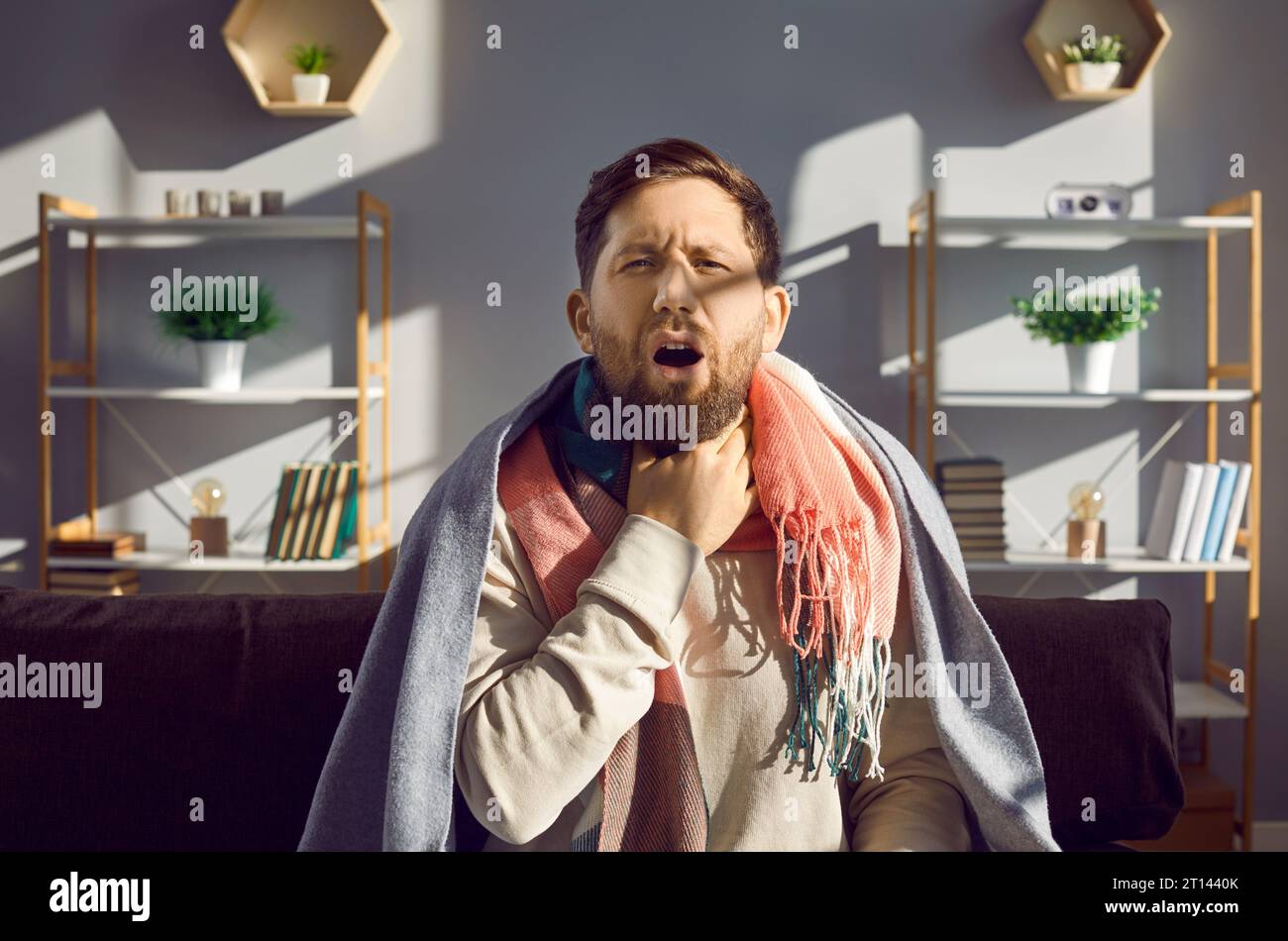 Sick man with touching his neck suffering from sore throat Stock Photo ...