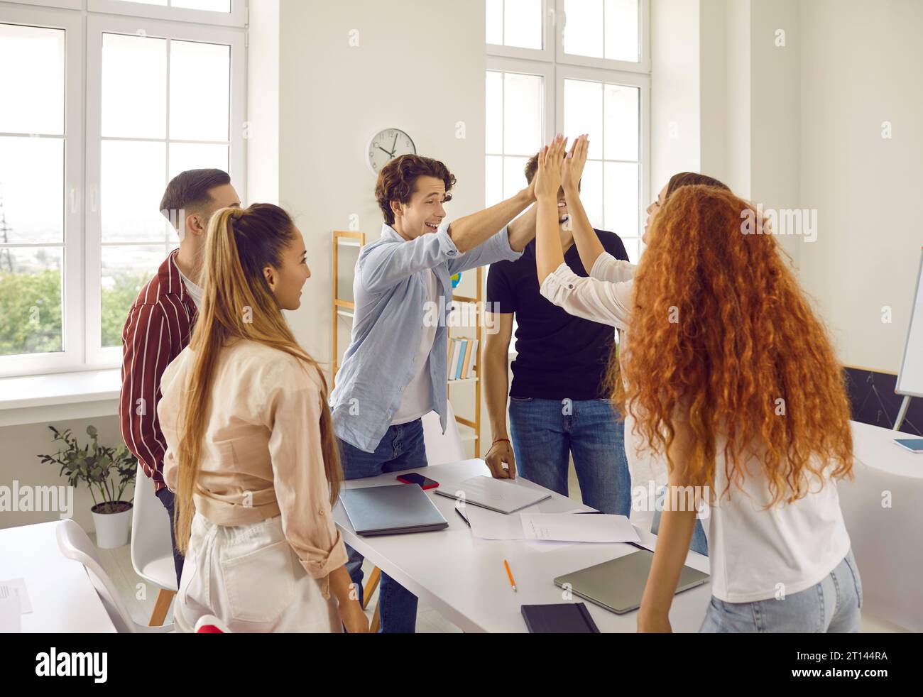 Students in class, two teen students are giving five each other another ...