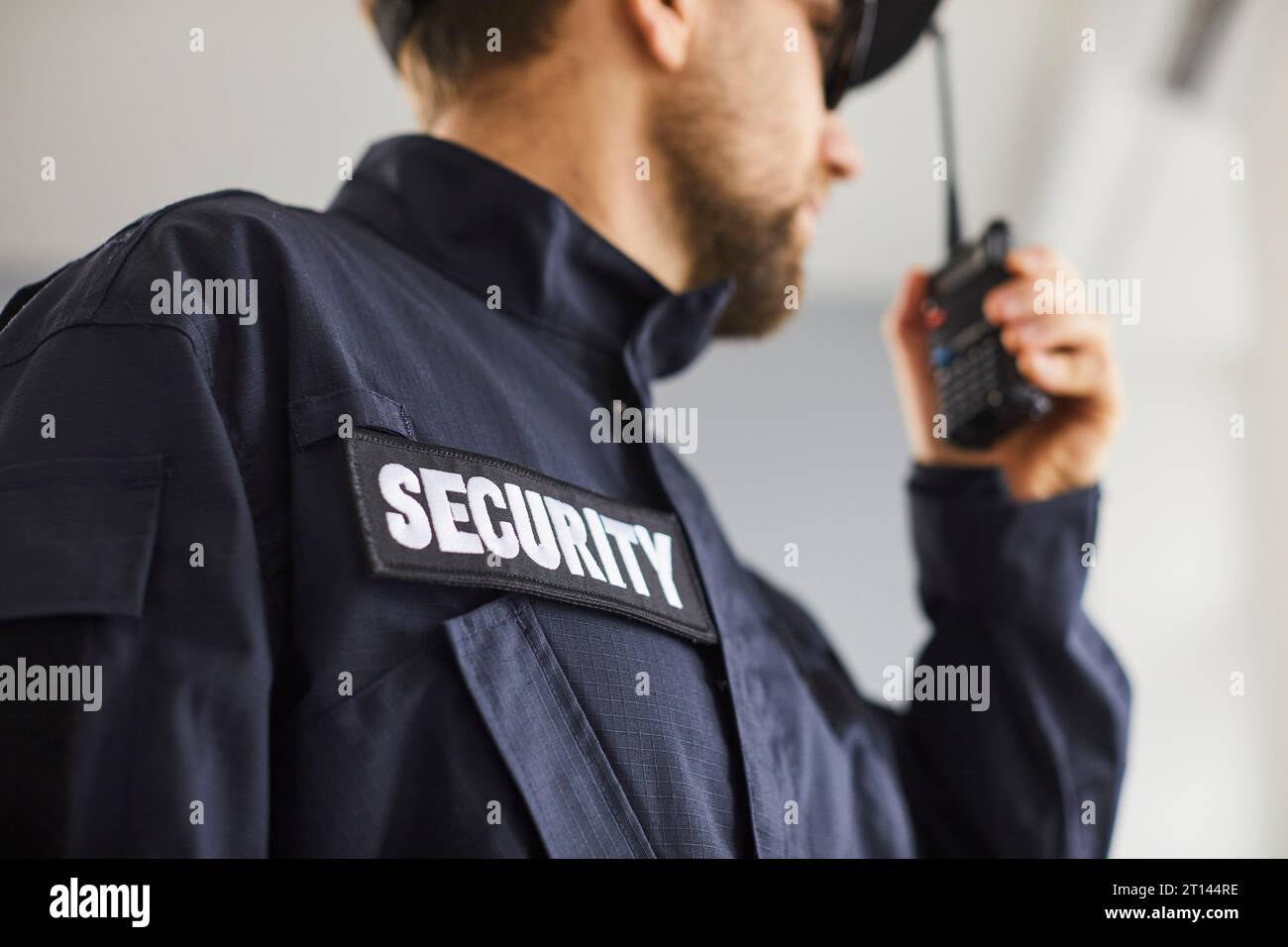 Portrait of male security guard man standing in uniform and talking by ...
