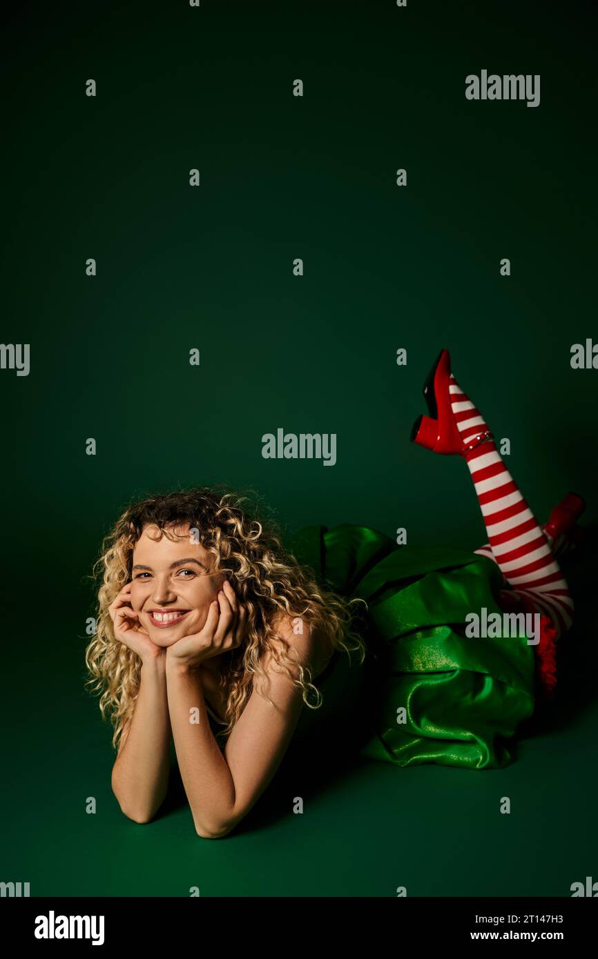 happy woman dressed as new year elf posing on floor with her legs ...