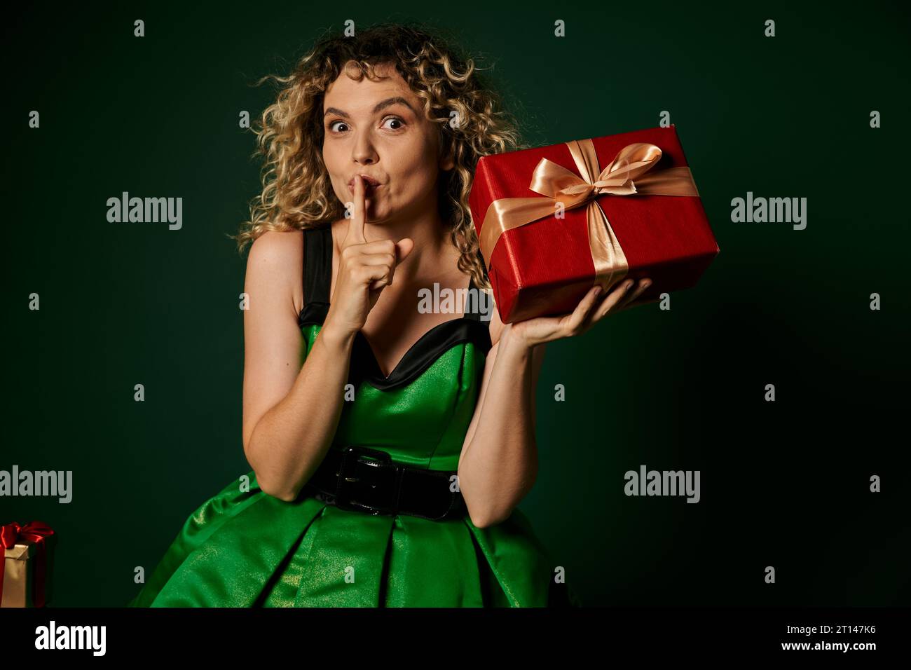 pretty elf posing in green dress with present in hands on green ...