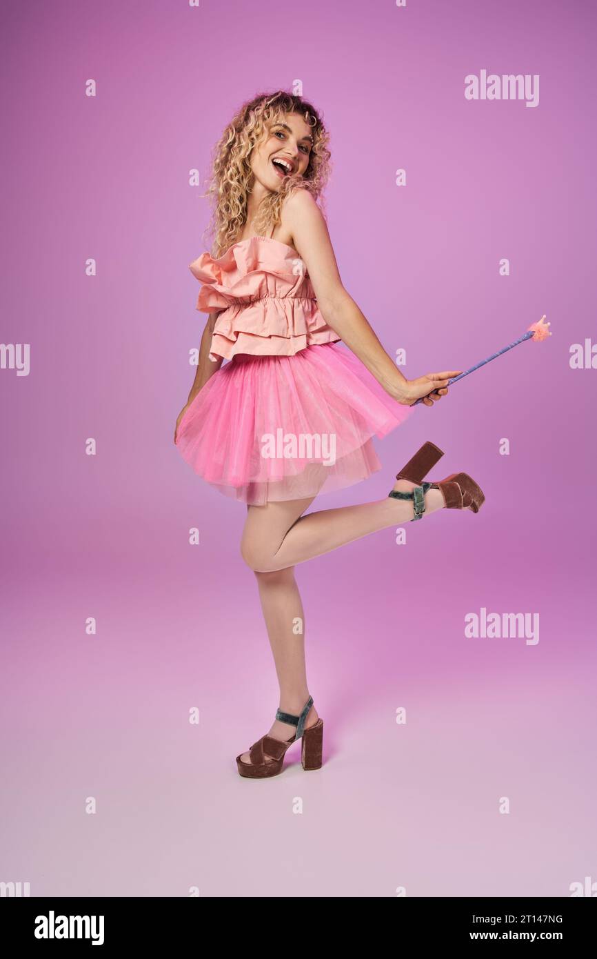 cheerful attractive woman in tooth fairy costume standing on one leg ...