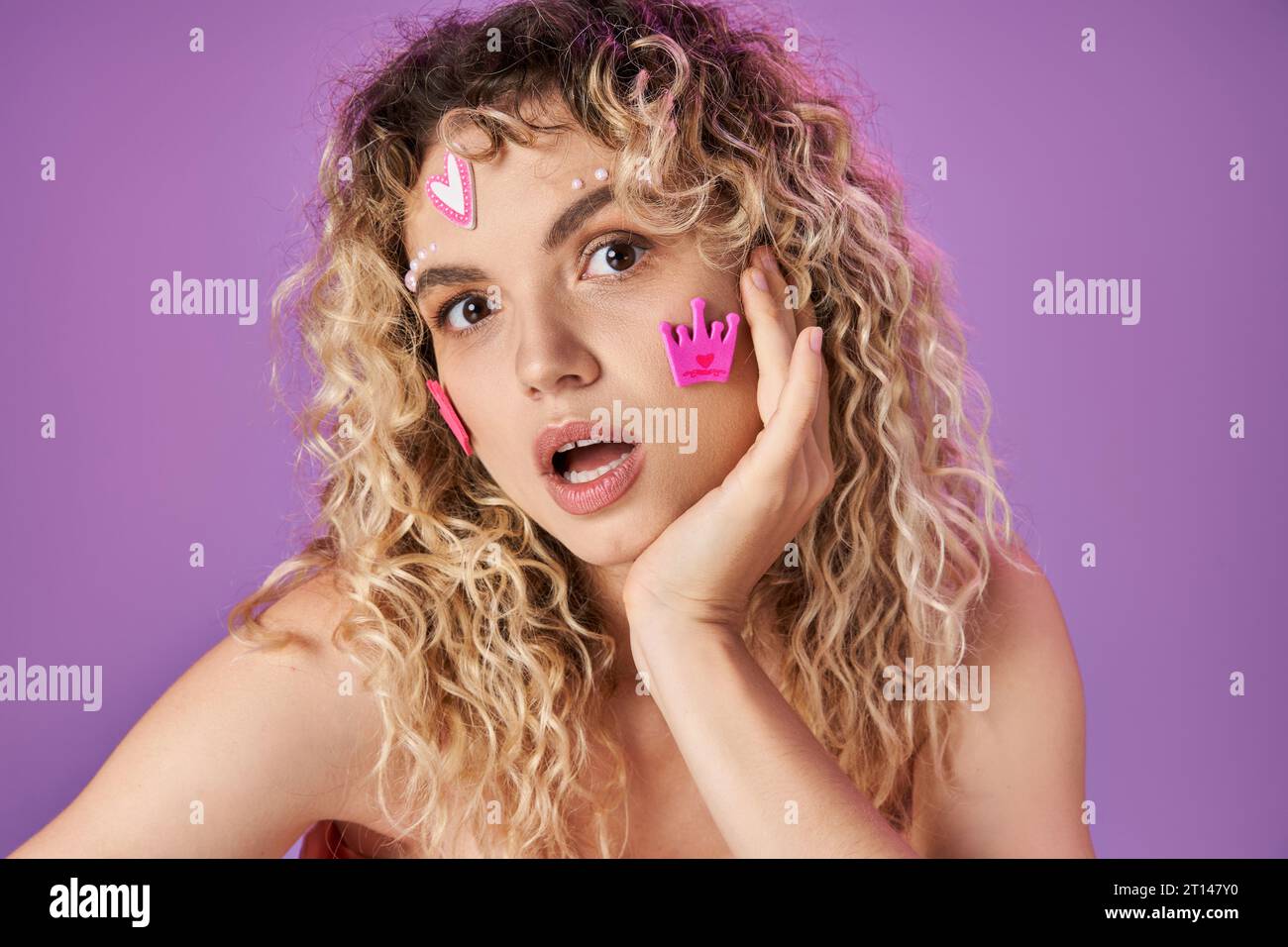 shocked lovely woman with blonde hair and vibrant face stickers looking ...