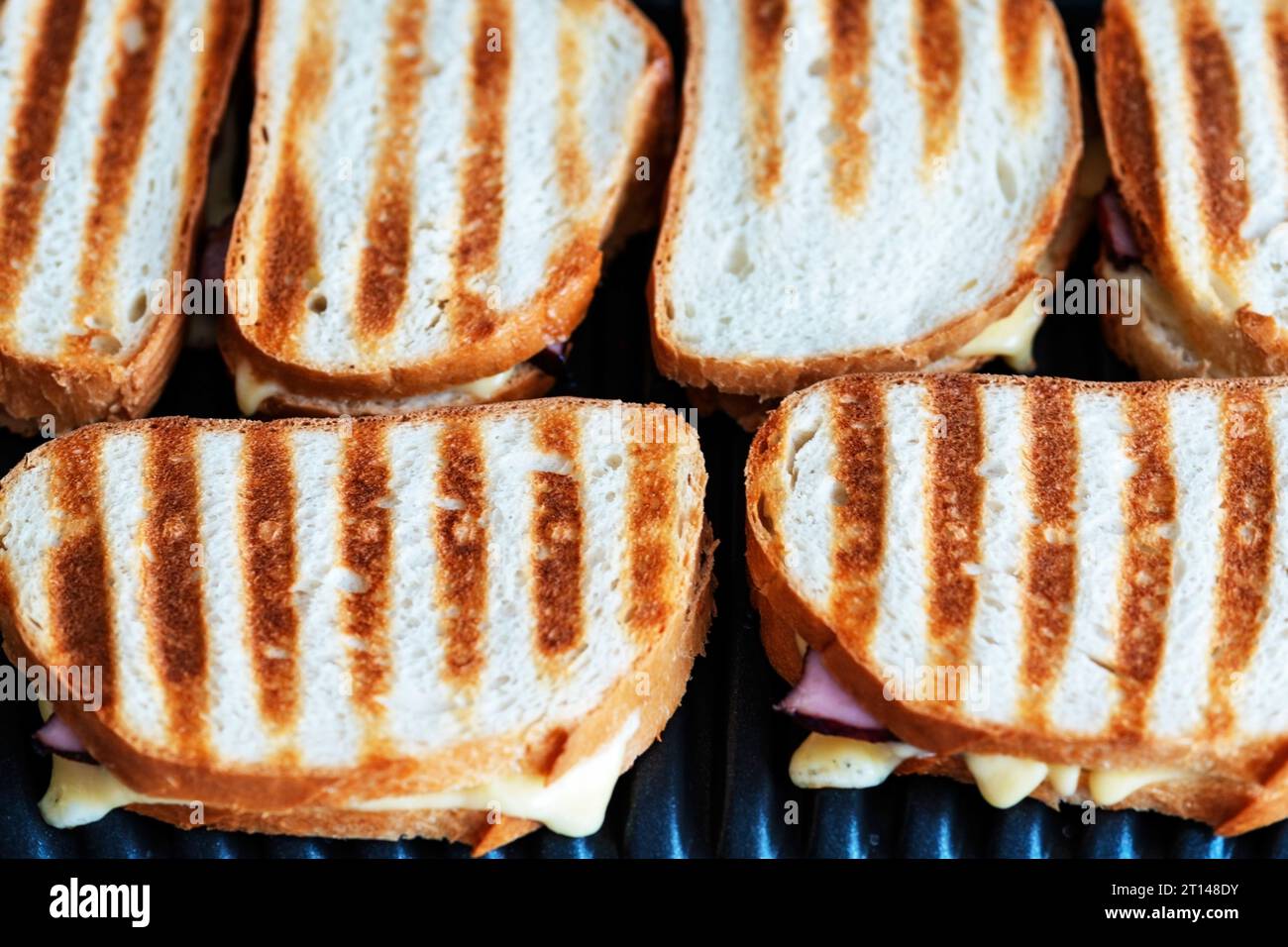 Fried toasts with cheese. The silicone shovel takes toasts from a grill ...