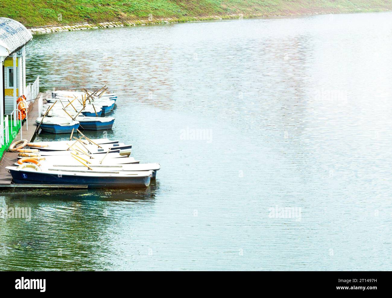 Two boats with oars on the mooring. Boats on pier with a lifebuoy ...
