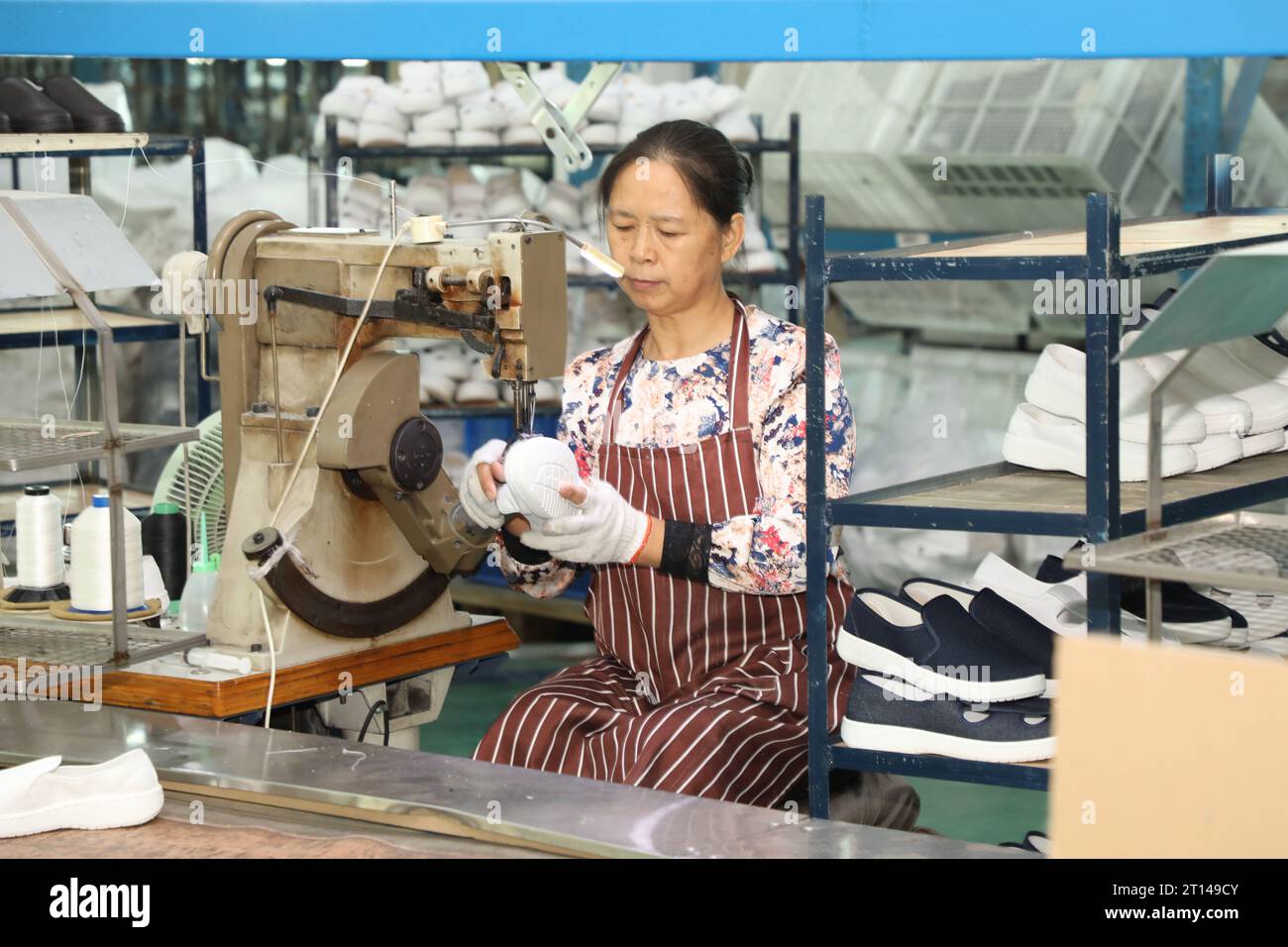 A worker works on the production line of a shoe processing plant in ...