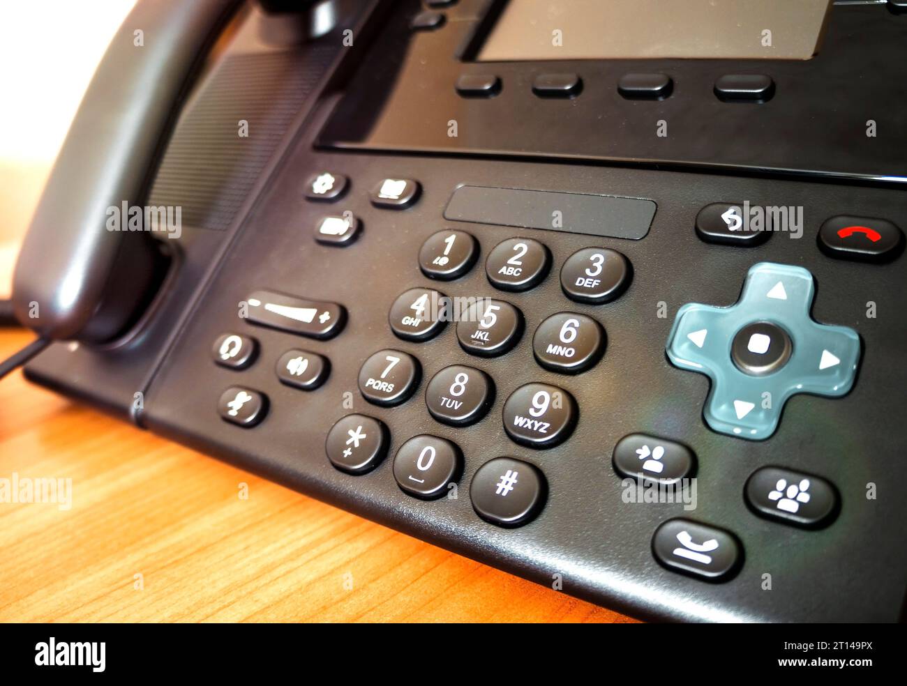 The black desktop push-button telephone. IP phone on desk in office ...