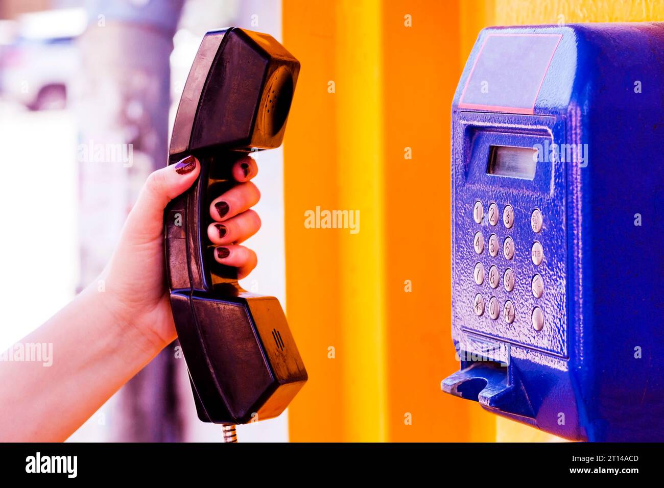 The hand holds a payphone tube. Close-up. Dialing a number with hand ...
