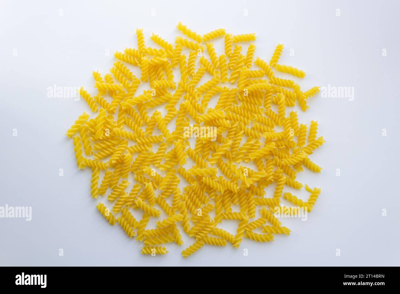 Yellow spiral pasta laid out in circle shape on white background. Pasta ...