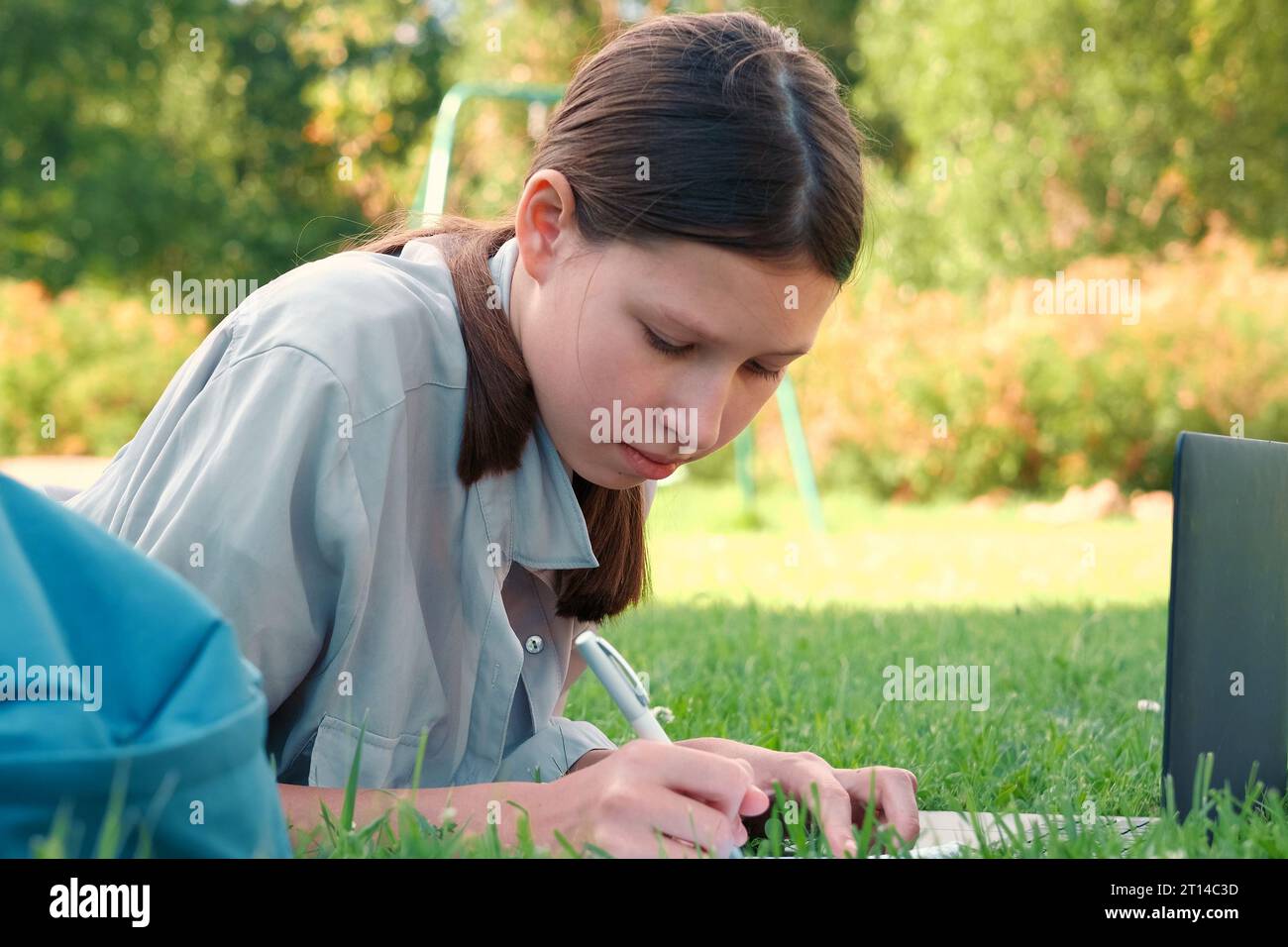 Teenage schoolgirl studying reading her books, tablet and notebook ...