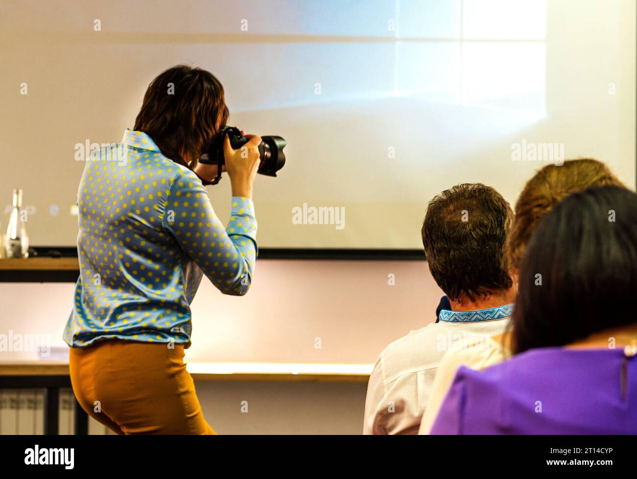 Photographer with a camera. The photographer photographs a meeting. The ...
