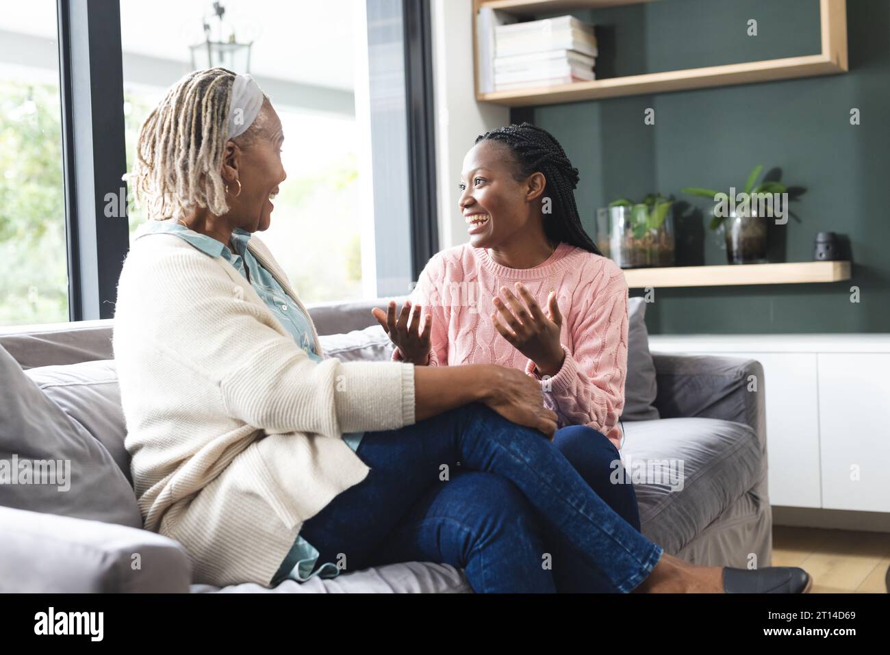 Happy African American Senior Mother And Adult Daughter Sitting On