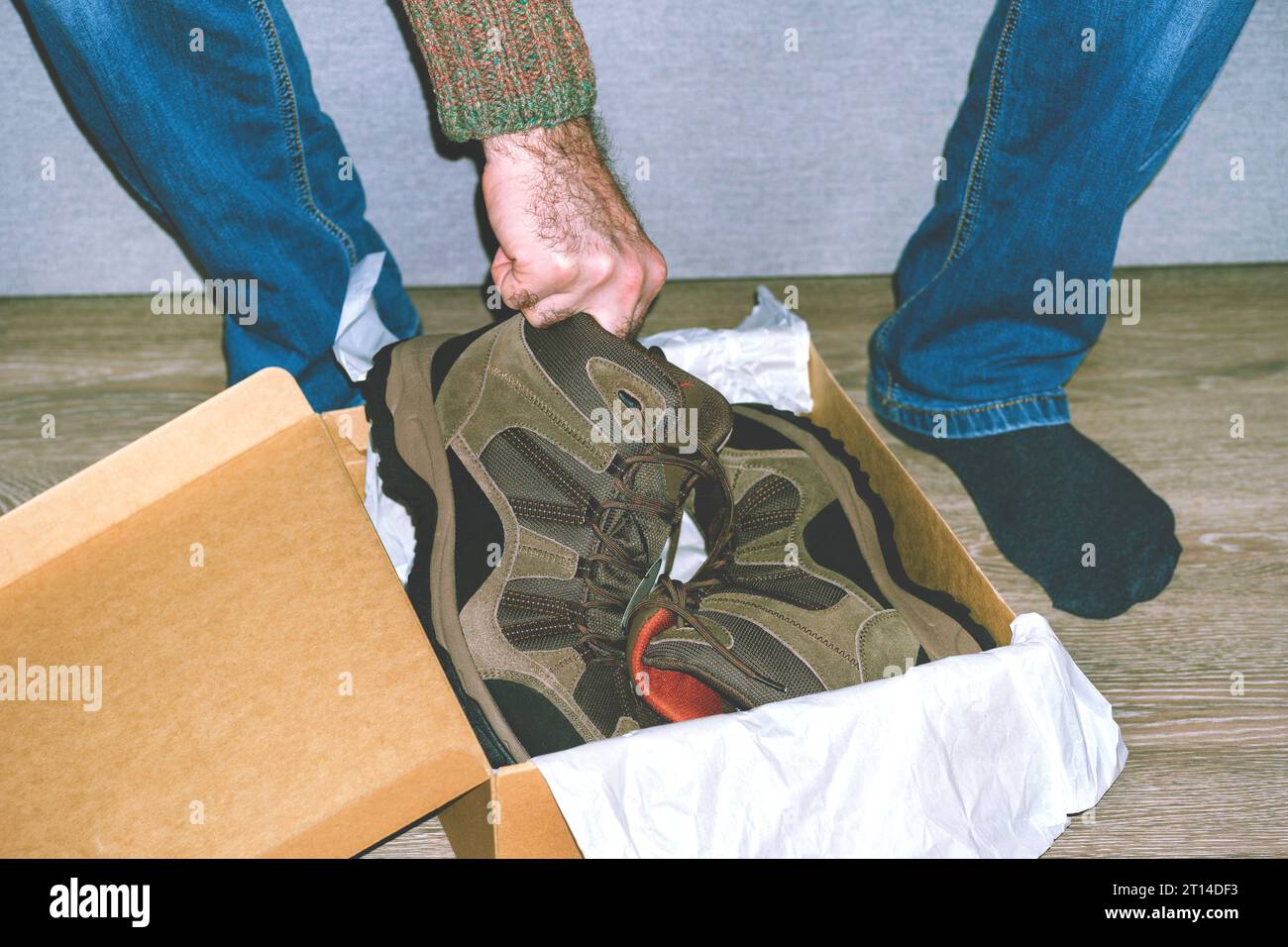 The man holds a boot in hand. Male hands show a high shoe. A man pulls ...