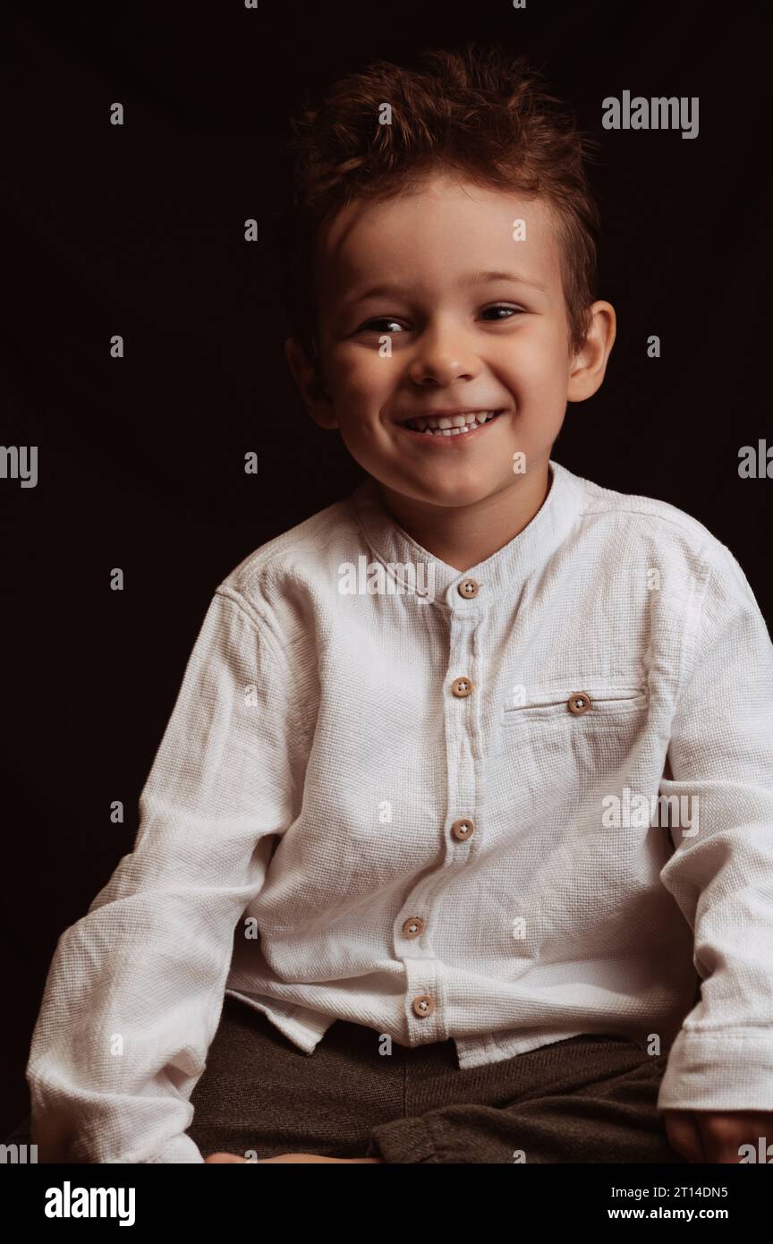 happy child boy preschooler smiling sitting on a chair Stock Photo - Alamy