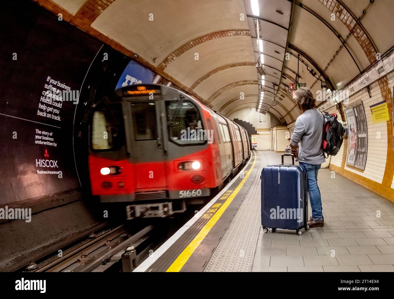 London, UK. Man with luggage waiting for a tube train at Tufnell Park ...