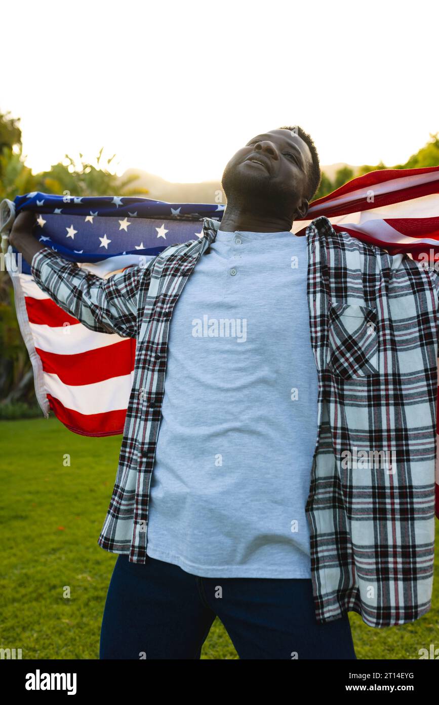 Happy african american man with flag on back american flag in sunny ...