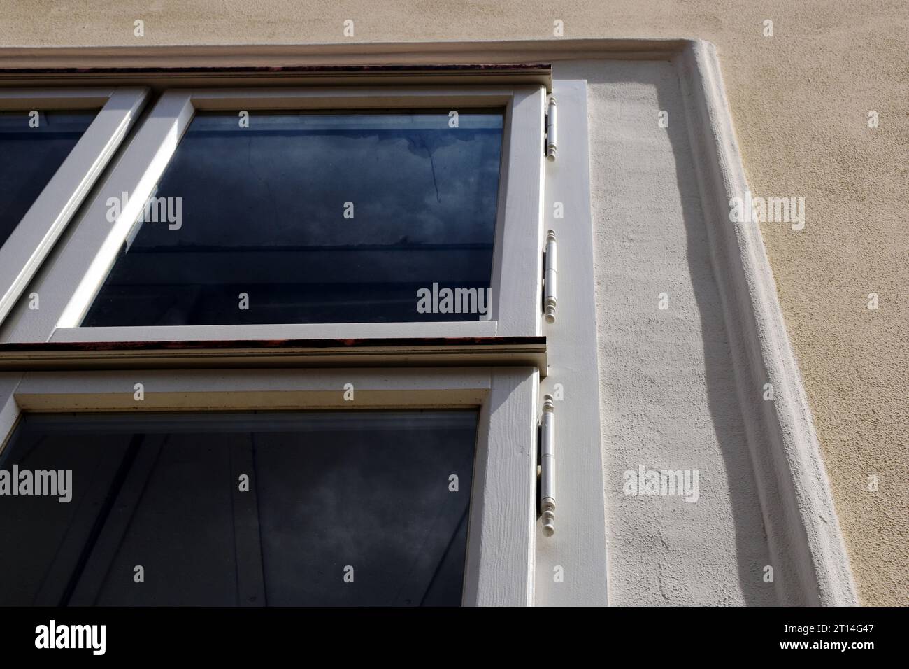 white painted wood window frame in stucco exterior wall. low angle view ...