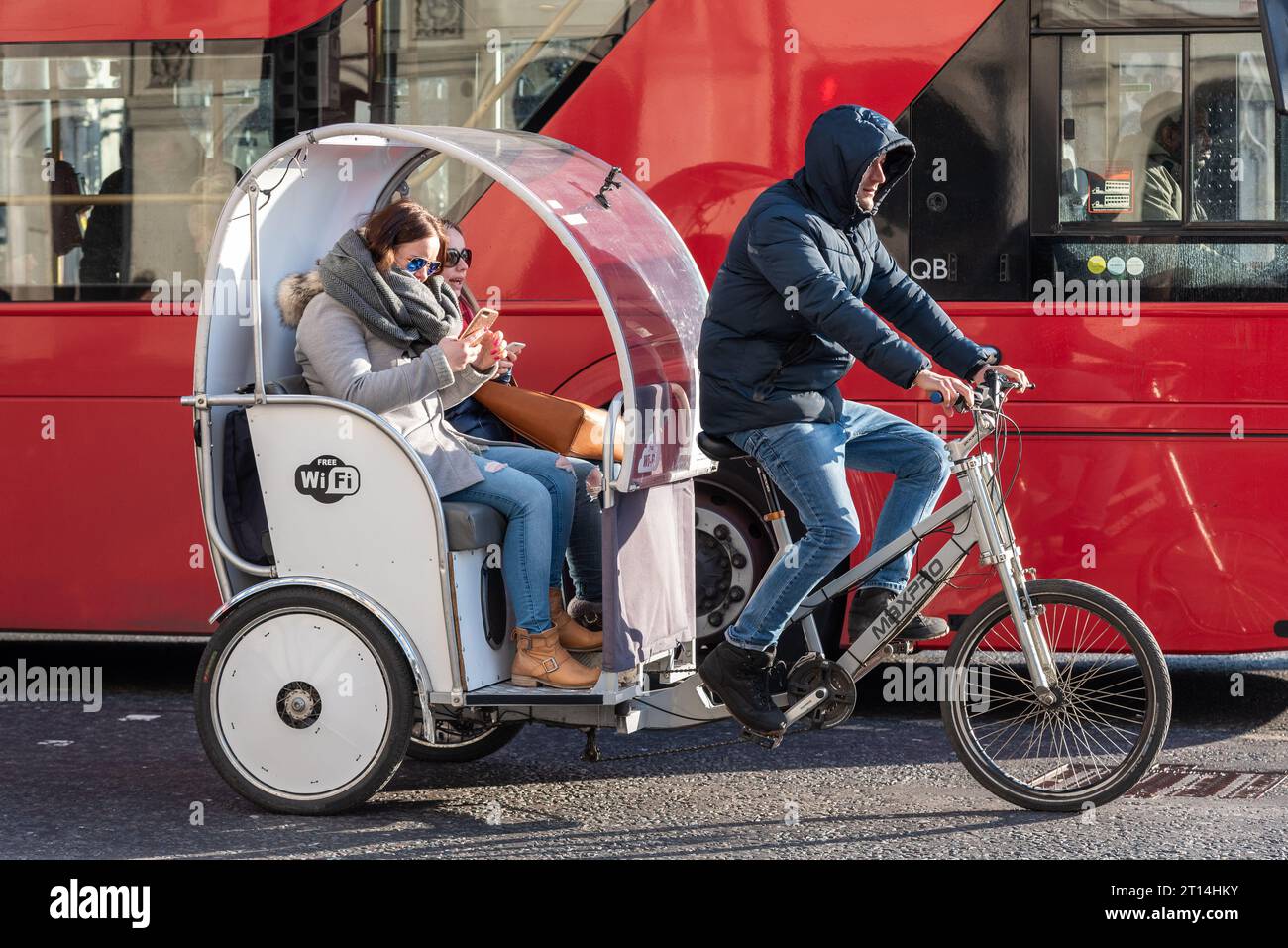 Transport options in London, UK. Pedicab, or rickshaw, with passengers ...