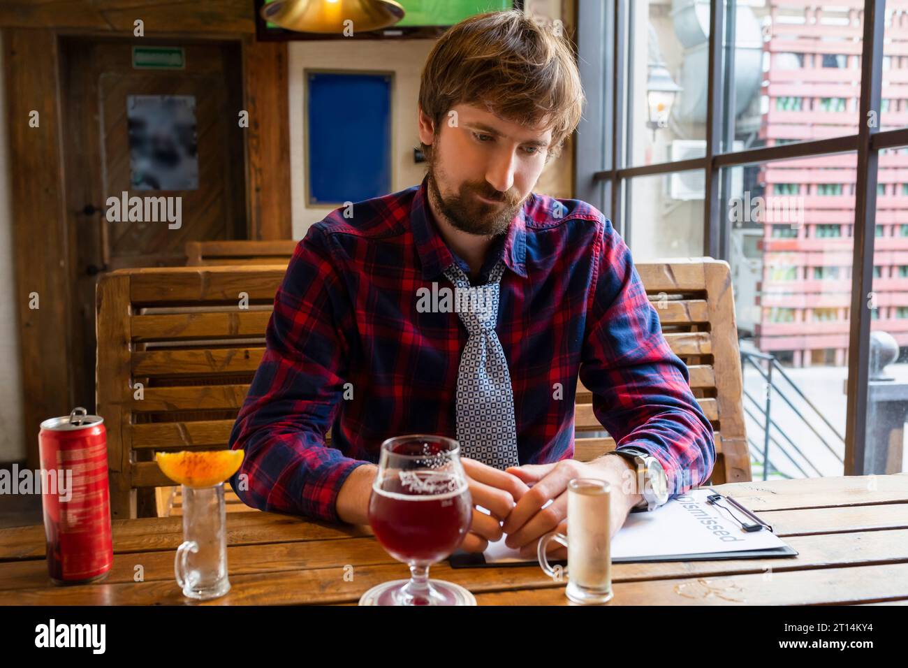 Alcoholism addiction concept. A frustrated young man drinking alcoholic sits alone in a bar ...
