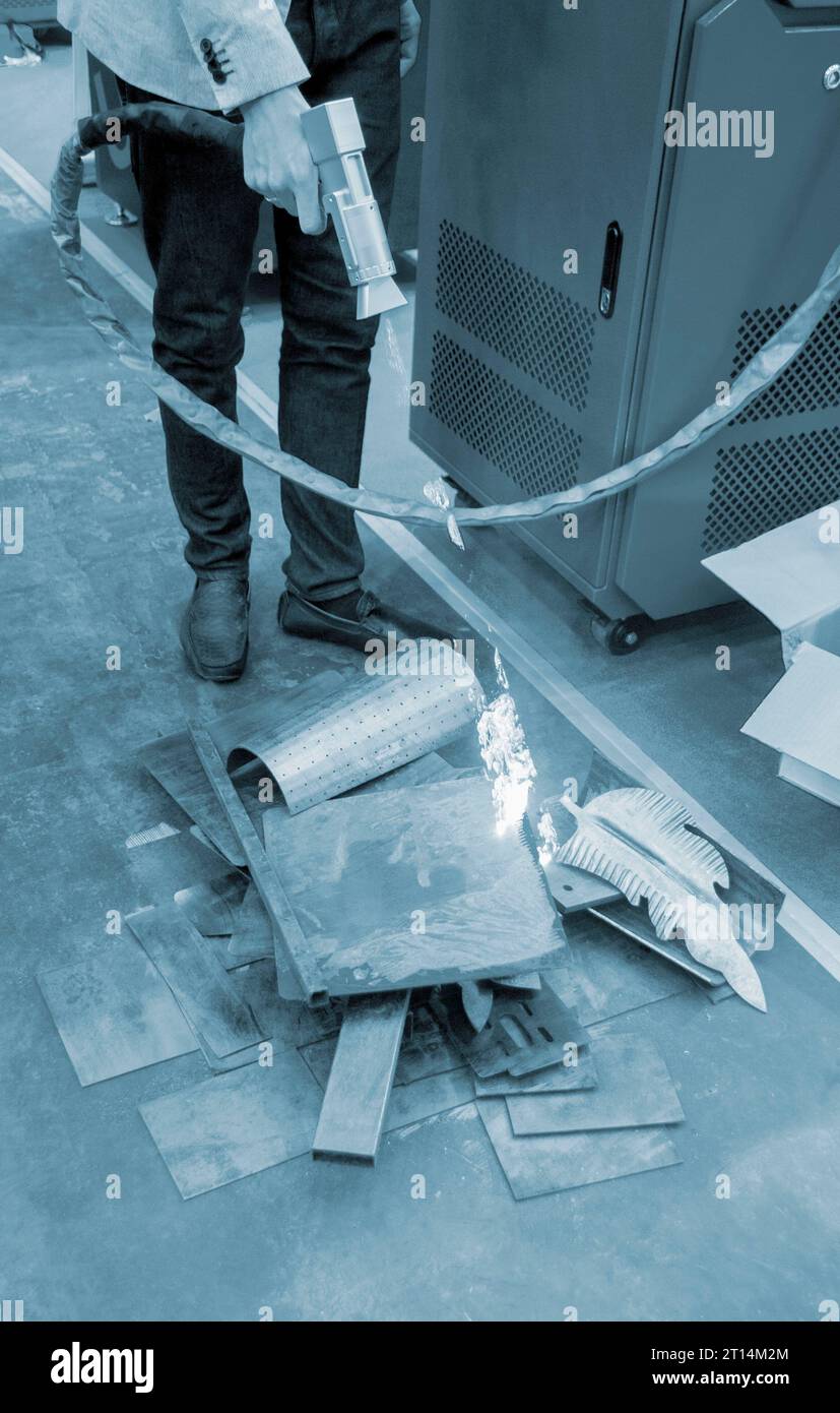 Laser metal cleaning. A man using laser metal cleaning machine to clean ...