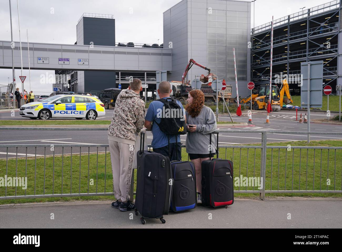 People stop to look at the scene following a fire at a multi-storey car ...