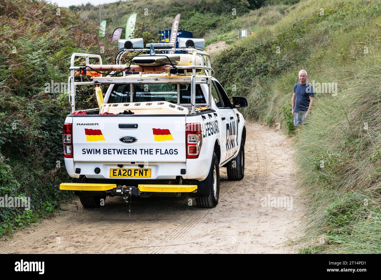 A RNLI emergency response vehicle driving along a sandy track at ...