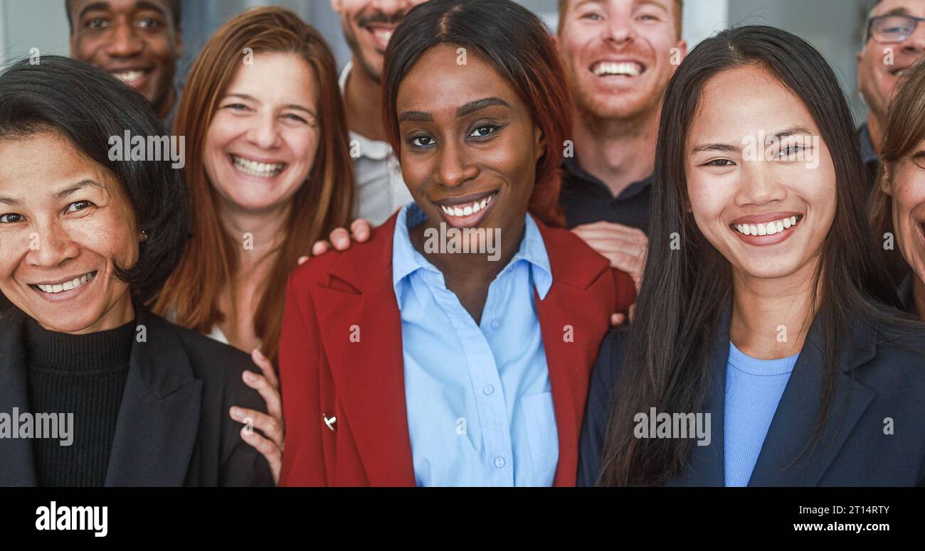 Multigenerational workers smiling in front of camera inside business ...