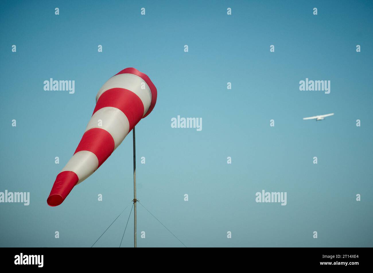 Windsock blown by the wind with small airplane on a background Stock ...