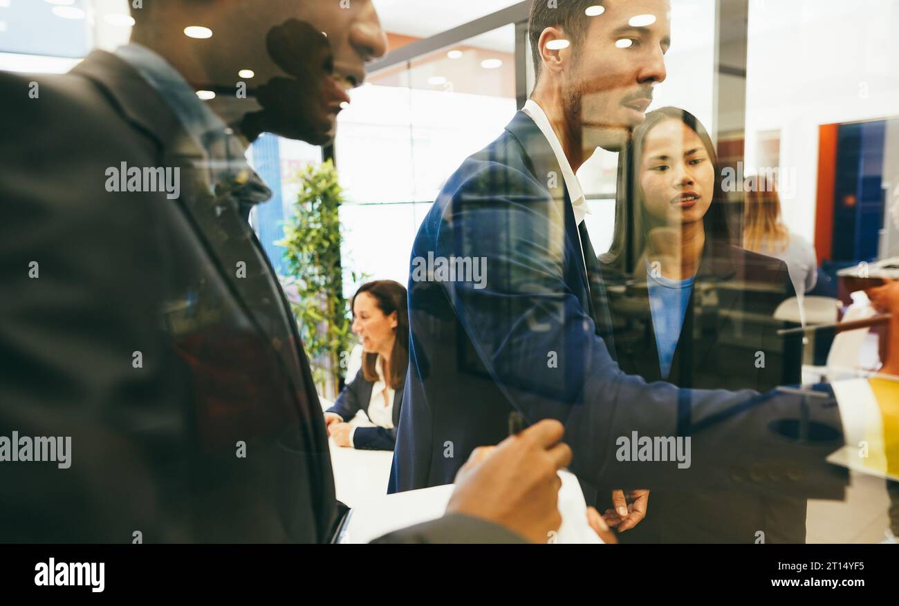 Multiracial colleagues working inside business office with glass walls ...