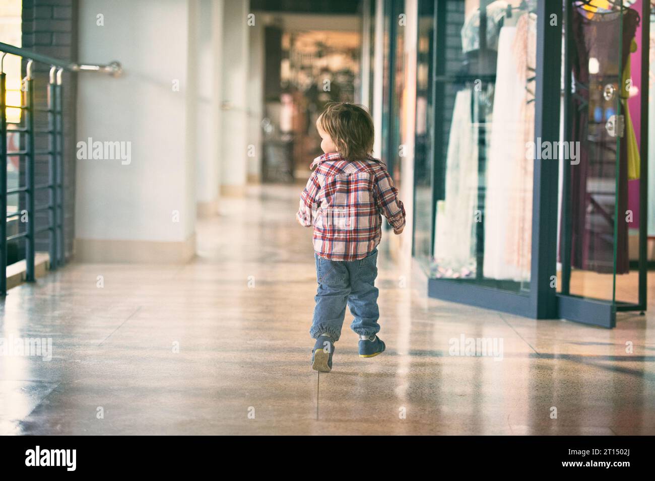 Little boy running in the shopping center. Back view. Vintage style ...