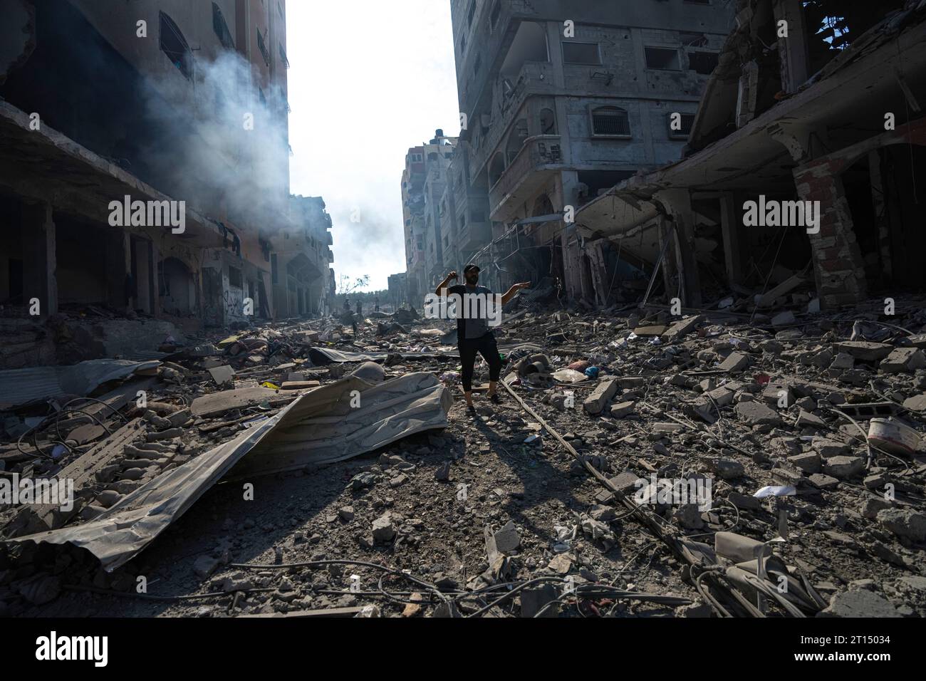 A Palestinian walks through the destruction by Israeli bombing in Gaza ...