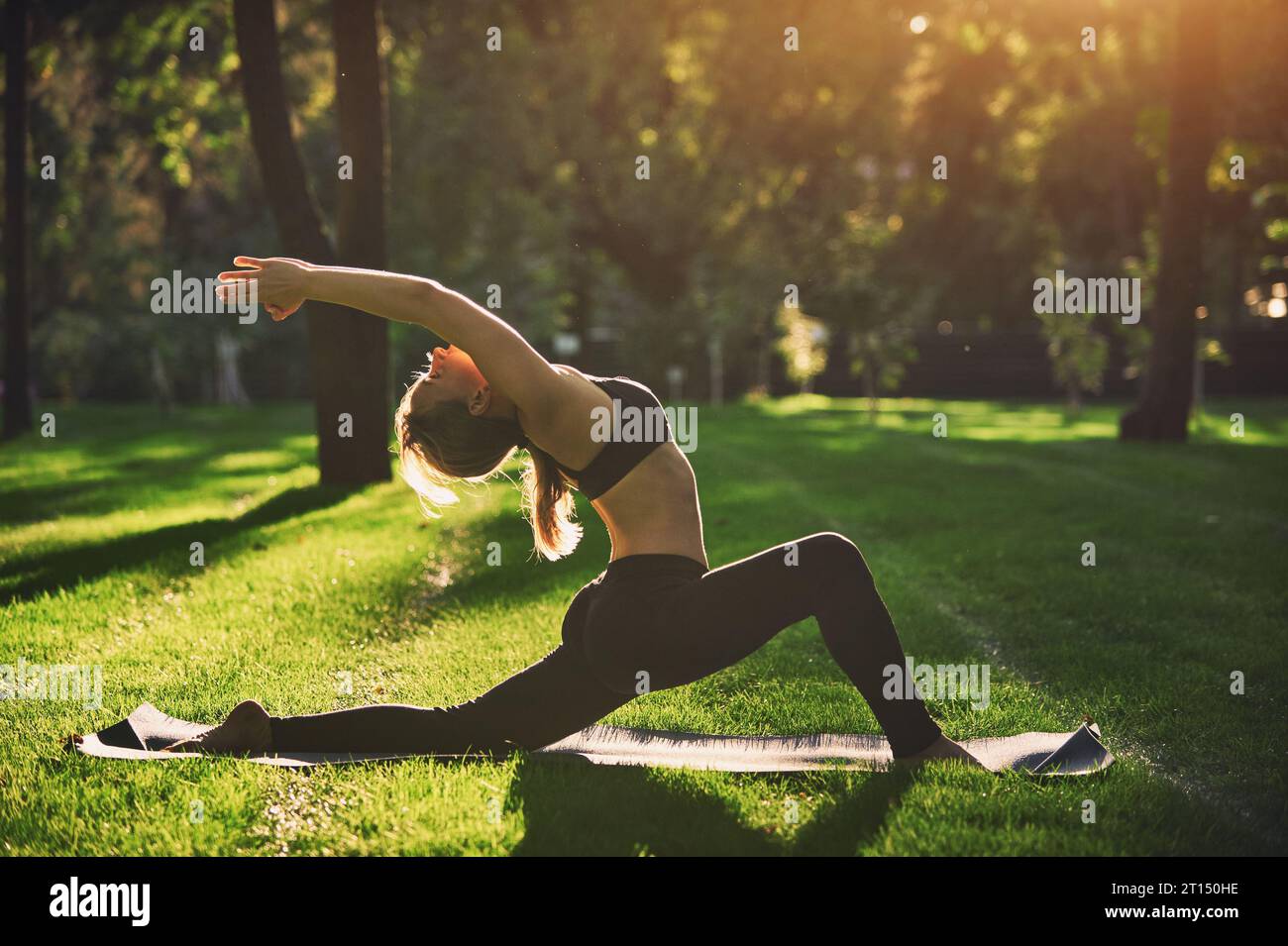 Beautiful sporty fit yogini woman practices yoga asana Virabhadrasana 1 ...