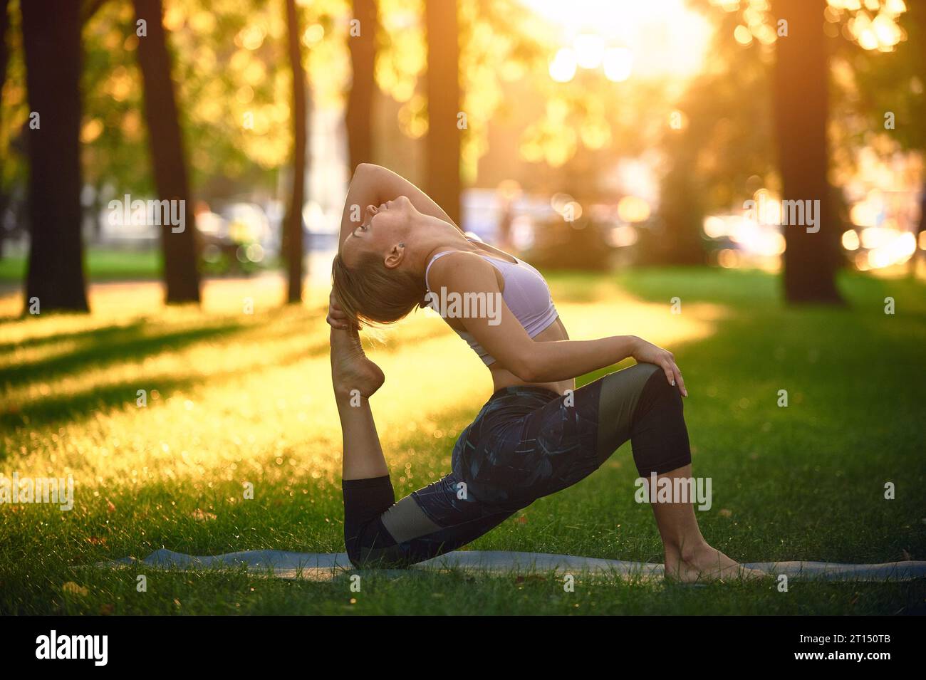 Beautiful sporty fit yogini woman practices yoga asana King Pigeon pose ...