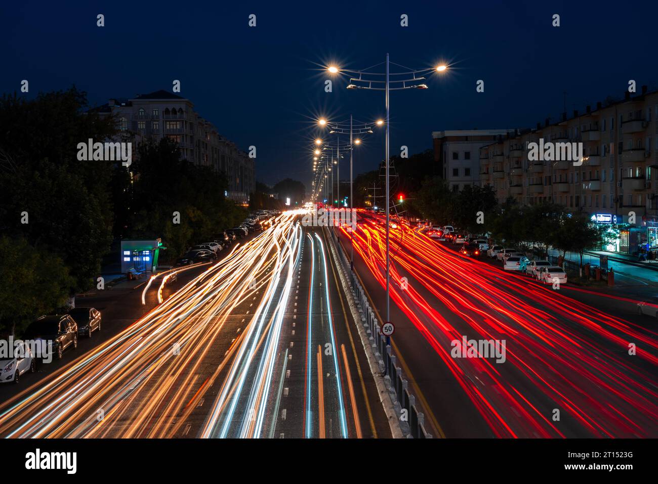 Traces of headlights of moving cars on the highway and street lights in ...