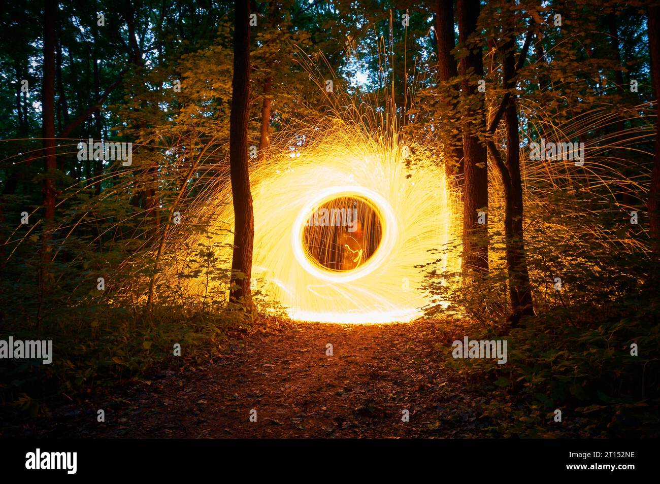 Burning steel wool spinned in the forest. Showers of glowing sparks ...