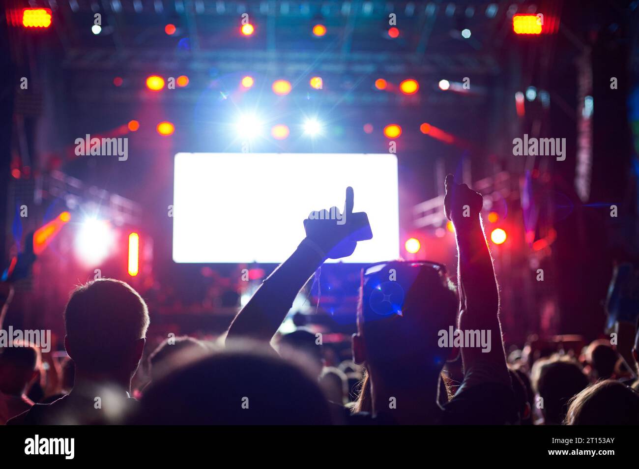 Crowd of audience with hands raised at a music festival. Lights ...