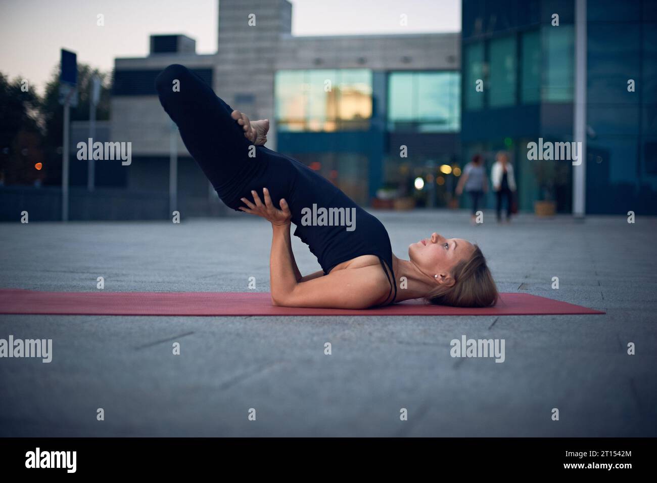Beautiful young woman practices yoga asana Padma Sarvangasana ...