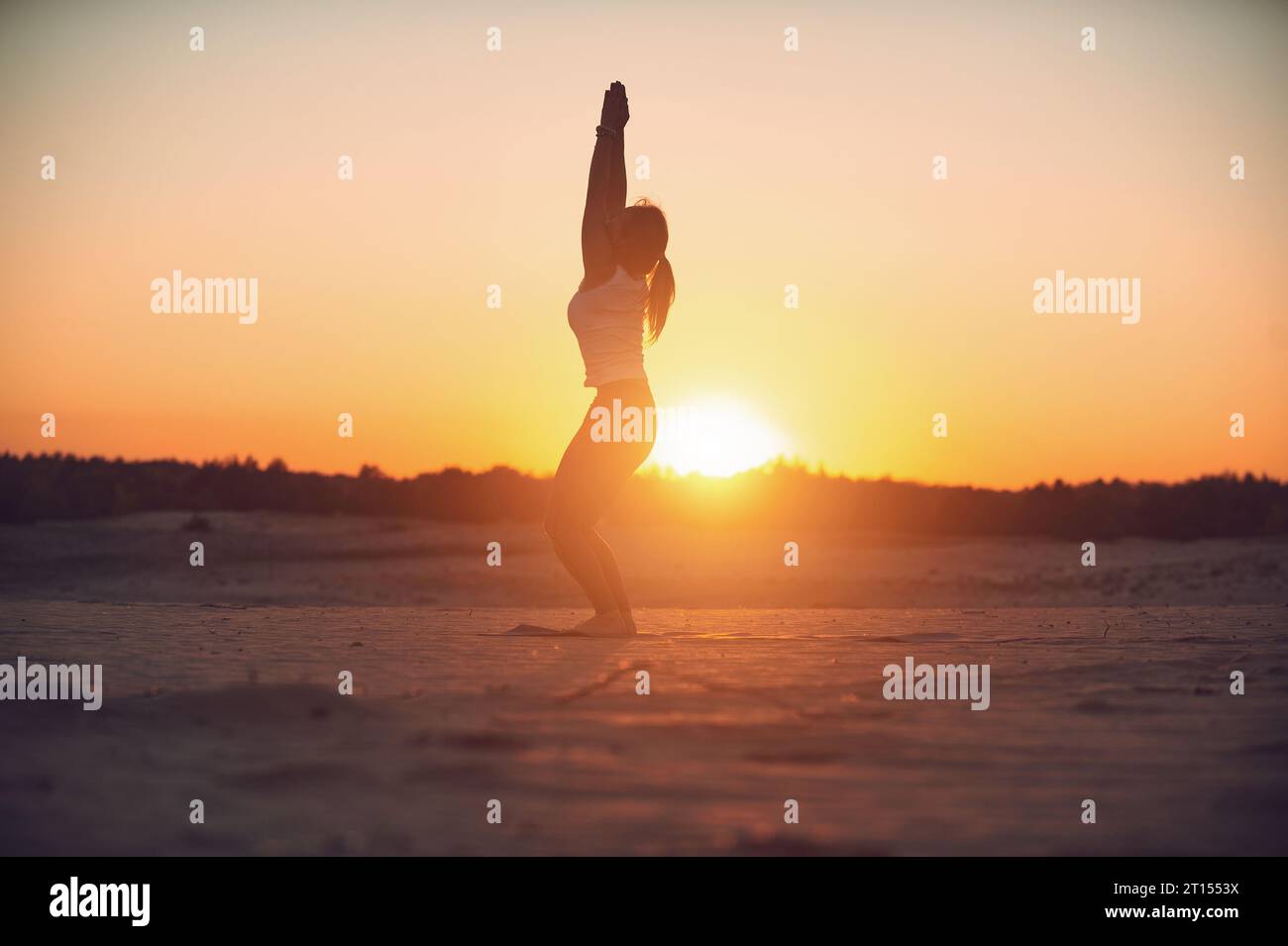 Beautiful young woman practices yoga asana Utkatasana - Chair pose in ...