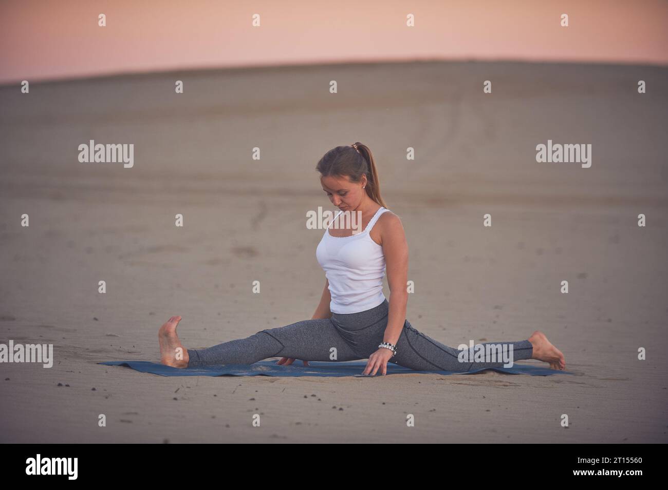 Beautiful young woman practices yoga asana Hanumasana - monkey king ...
