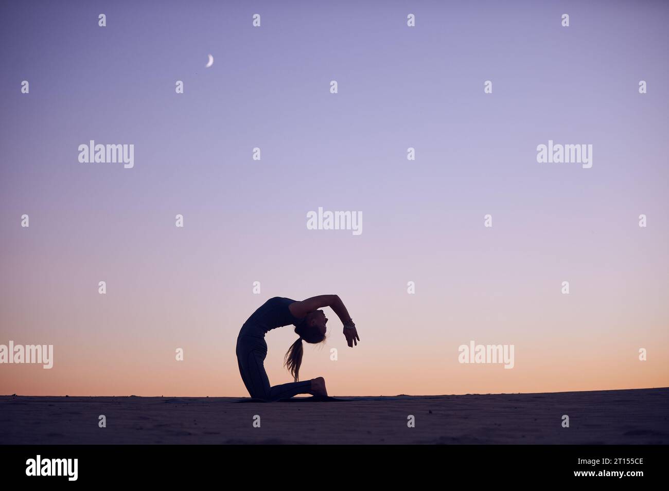 Beautiful young woman practices advanced variation of camel pose ...