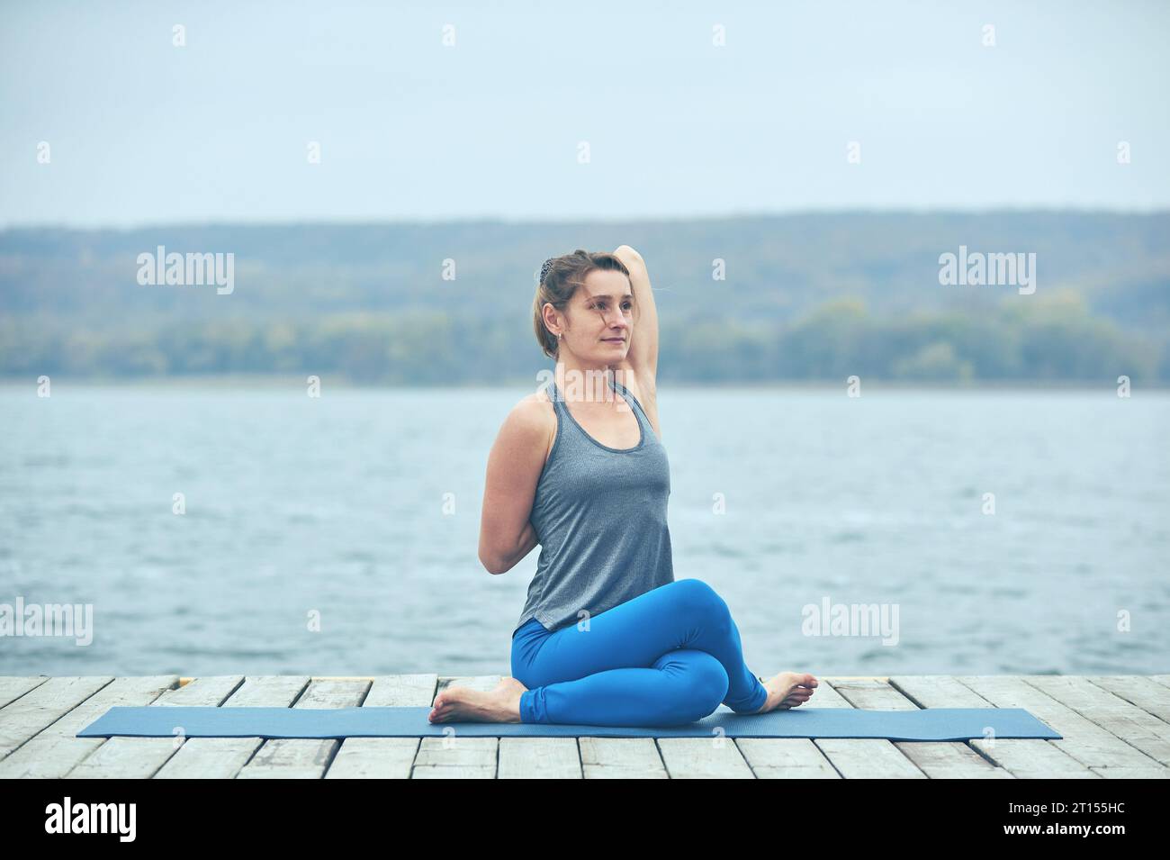 Beautiful young woman practices yoga asana Gomukhasana - Cow face pose ...