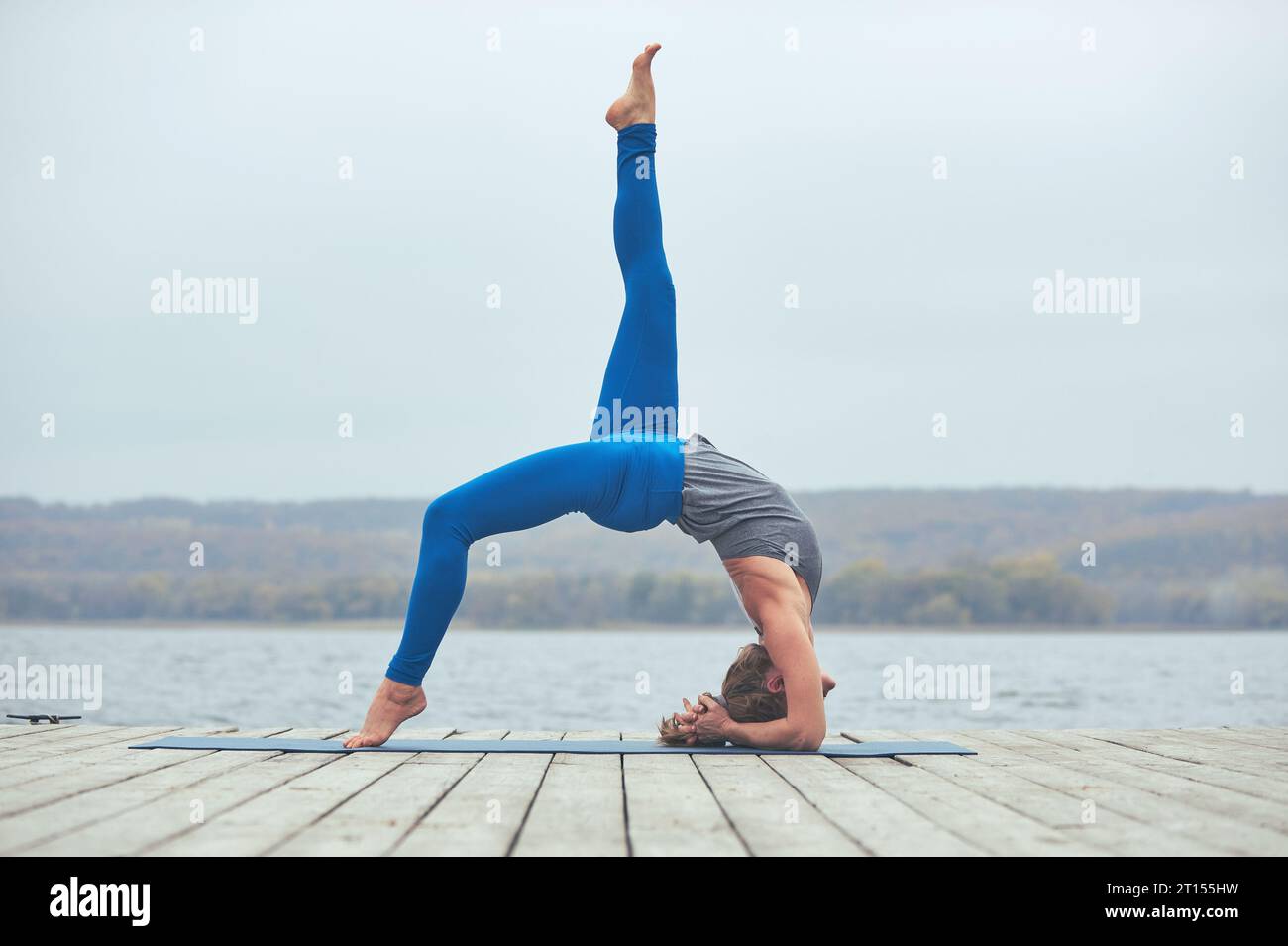 Beautiful young woman practices backbend yoga asana Eka Pada Urdhva ...