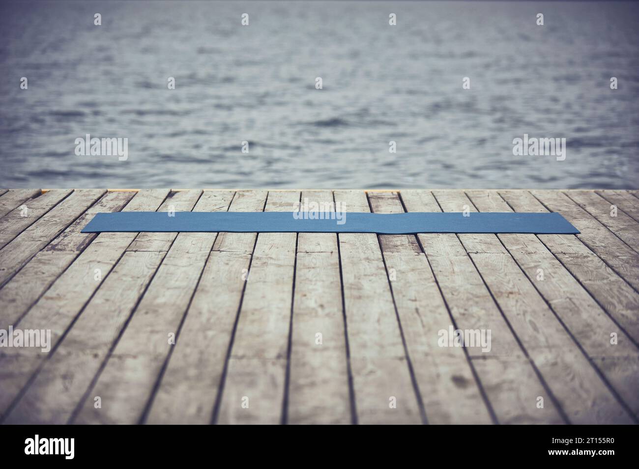 wooden deck near the lake and unrolled yoga mat on the floor Stock ...