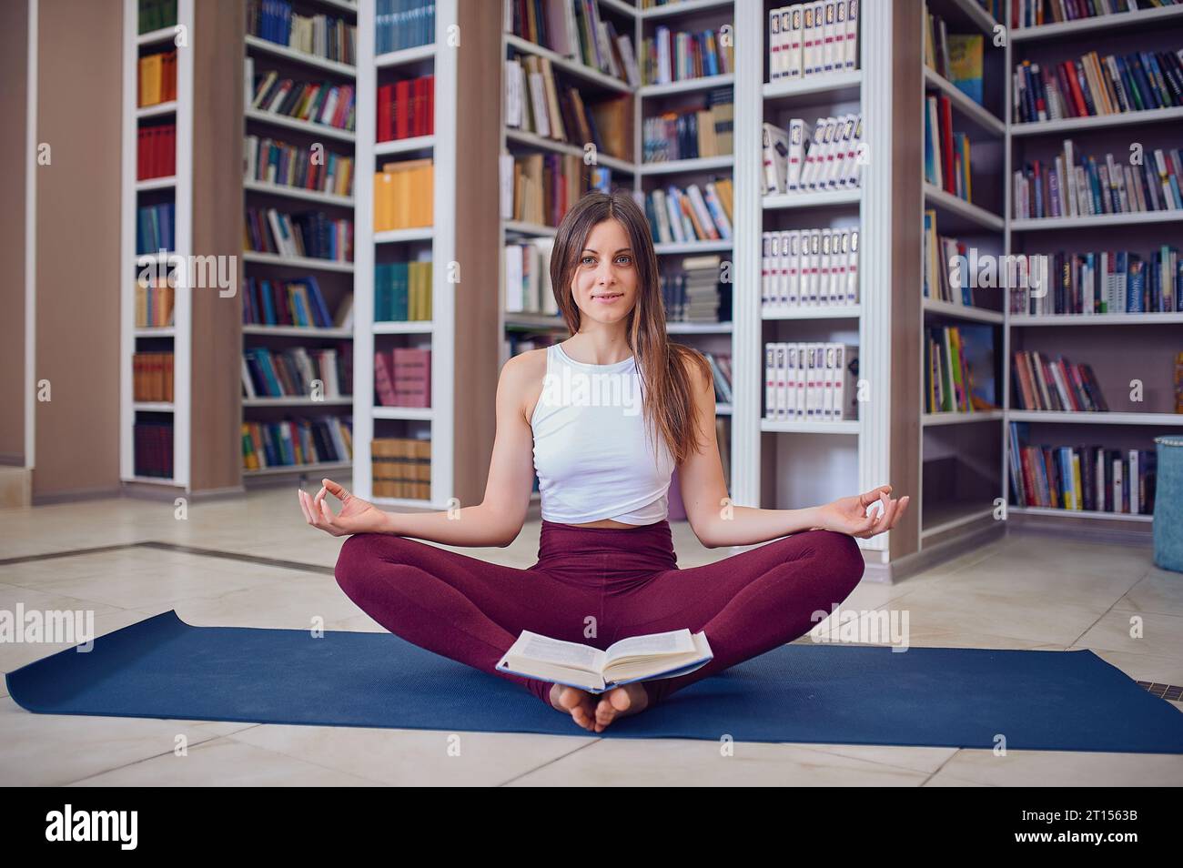Beautiful woman reading book and practices yoga asana Baddha Konasana ...