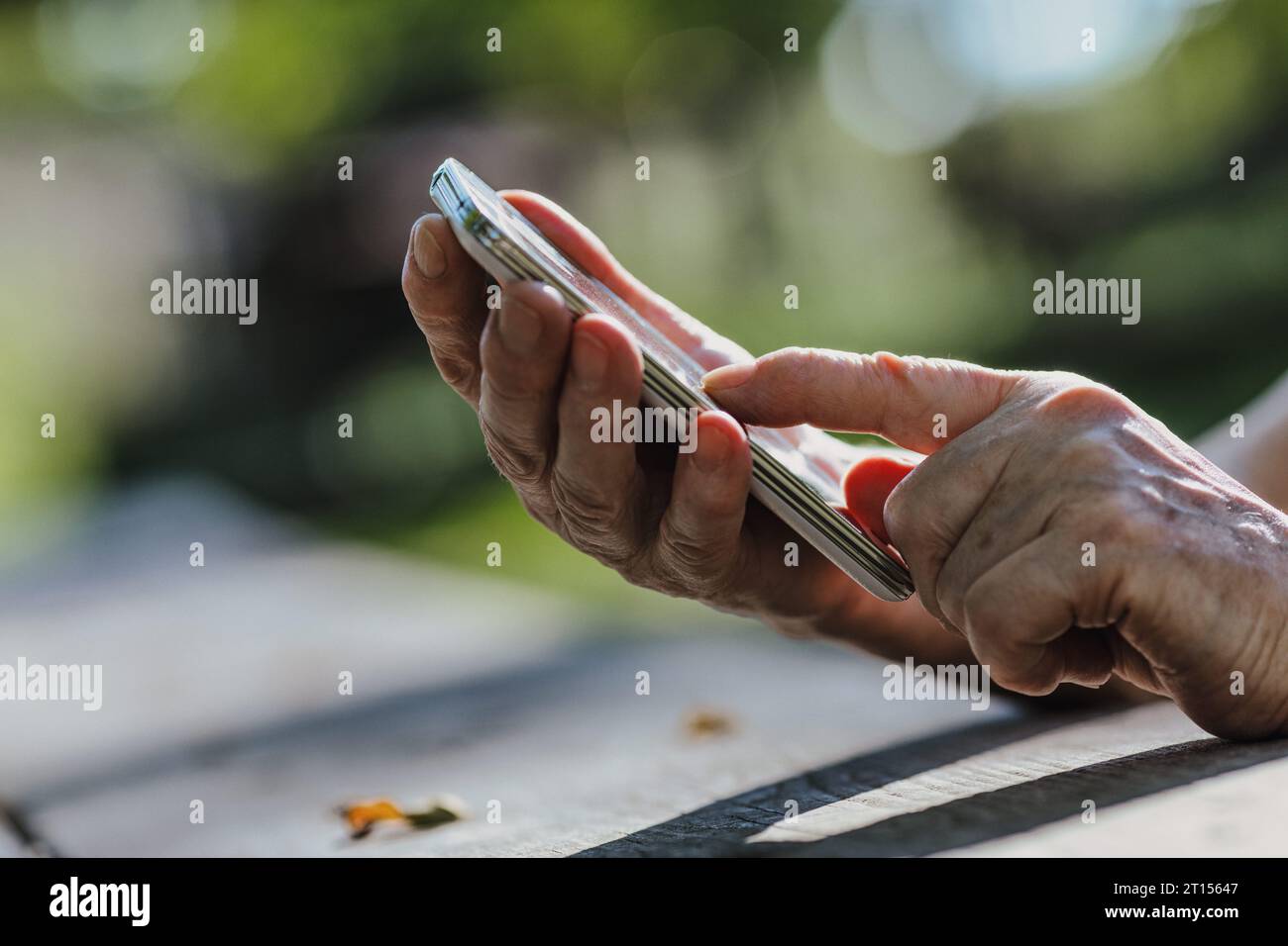 On rugged park wood, a senior's fingers wrestle with a phone. Today's ...