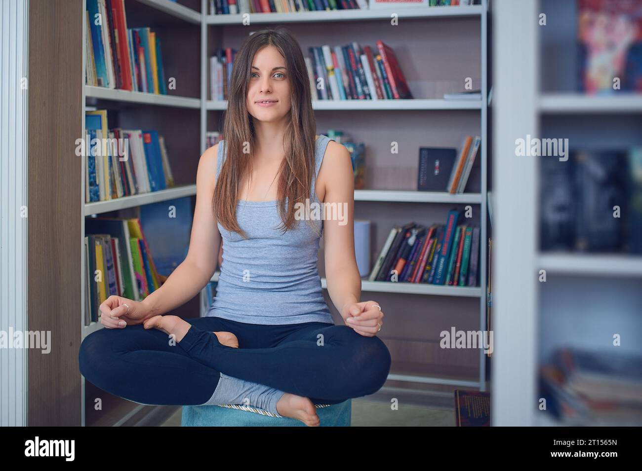 Beautiful woman practices yoga asana Ardha Padmasana - half lotus pose ...