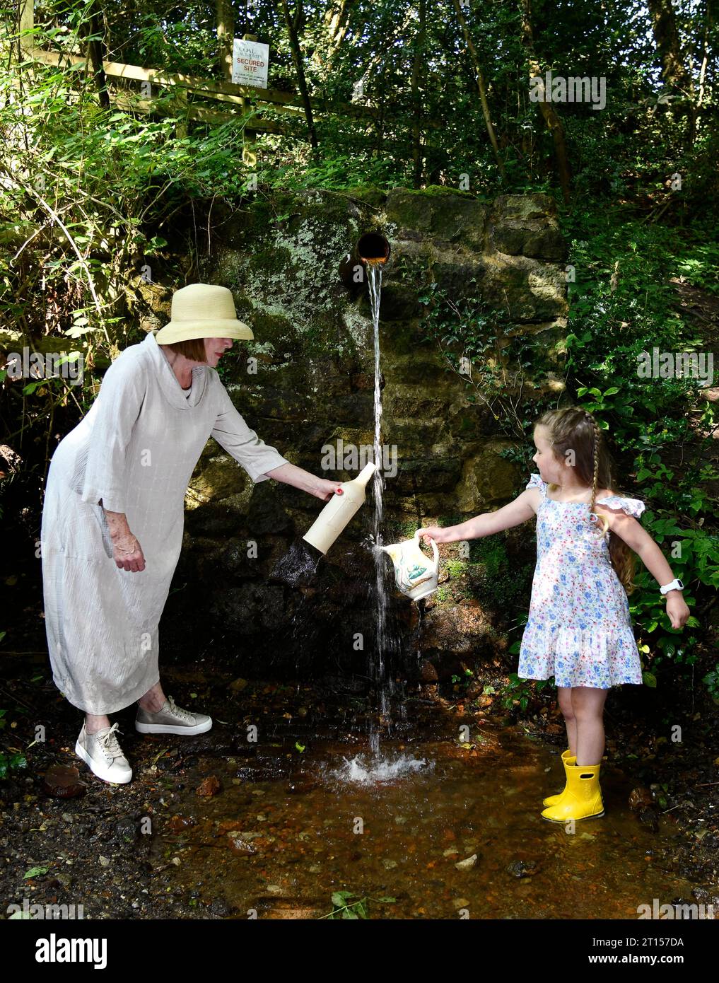 Woman and child collecting fresh spring water from Mine Spout water ...