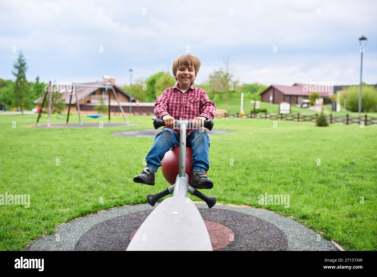 Outdoors portrait of cute preschool laughing boy swinging on a swing at ...